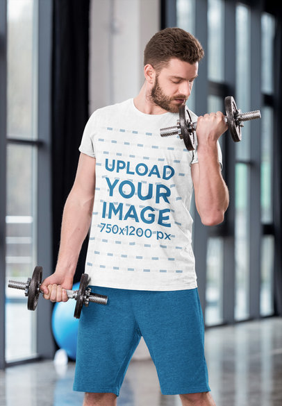 Placeit - T-Shirt Mockup of a Muscular Man Doing Bicep Curls at the Gym