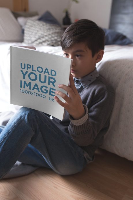 Placeit - Boy Reading a Square Book Mockup Sitting Against his Bed