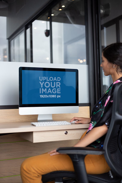 Placeit - Woman with a Man Working at a Modern Office with an iMac Mockup