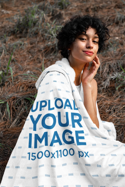 Placeit - Mockup of a Young Woman Covered with a Hooded Fleece Blanket