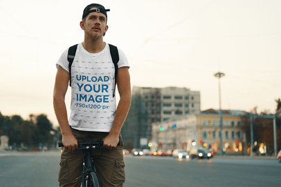 Placeit - T-Shirt Mockup Featuring a Man with a Bicycle on the Street