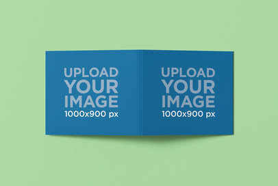 Placeit - Minimalistic Mockup of a Digipak on a Colored Surface